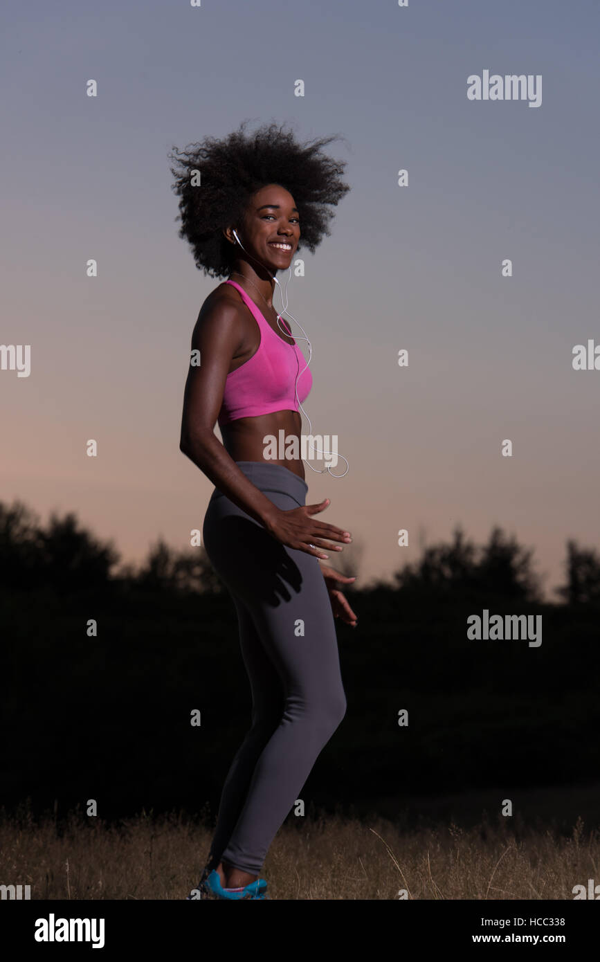 Young healthy black woman is doing stretching exercise relaxing and ...