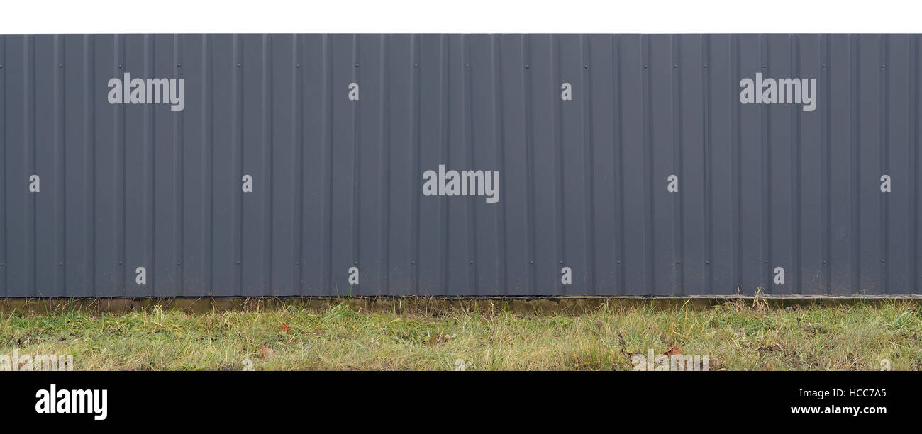 Solid armored fence made of strong corrugated steel sheets. Isolated on ...