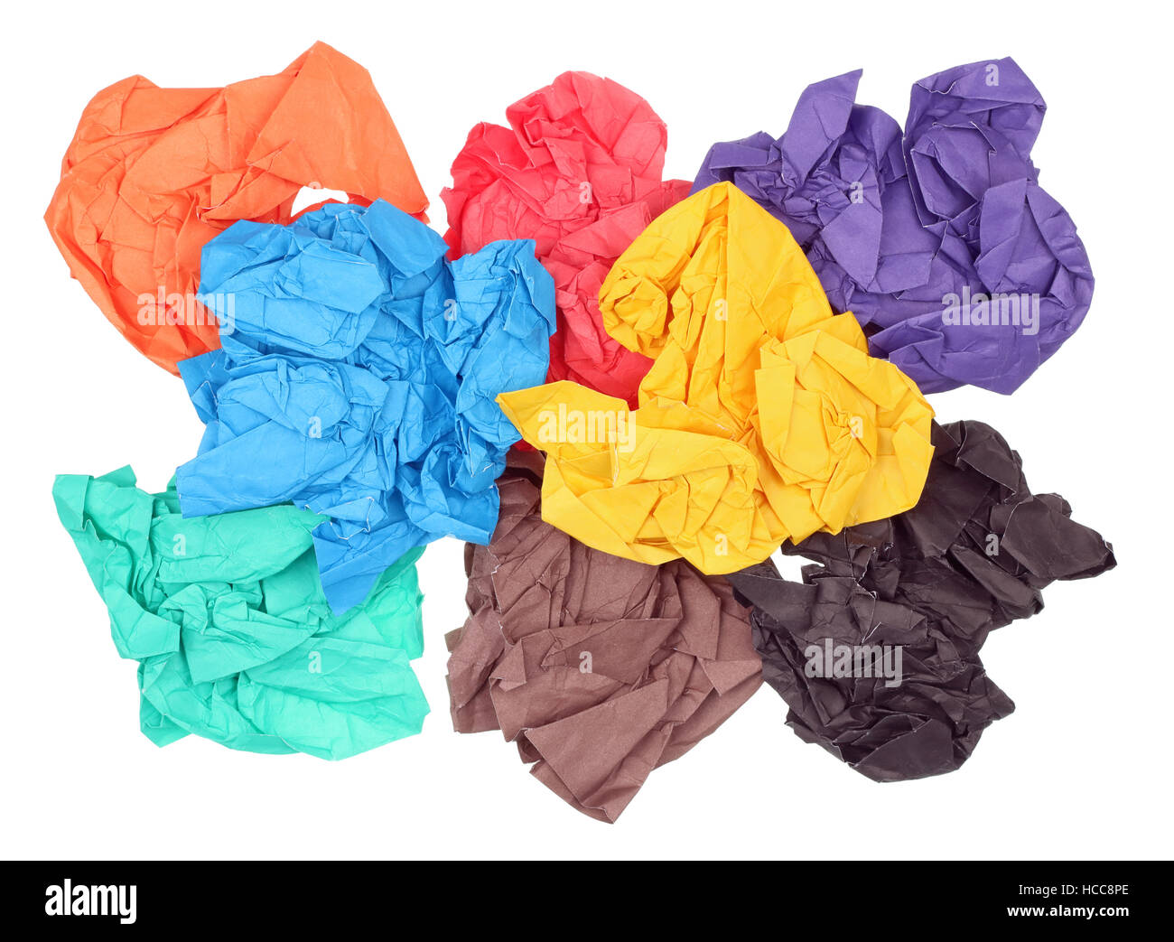 The crumpled paper sheets of different colors lie on a white table ...