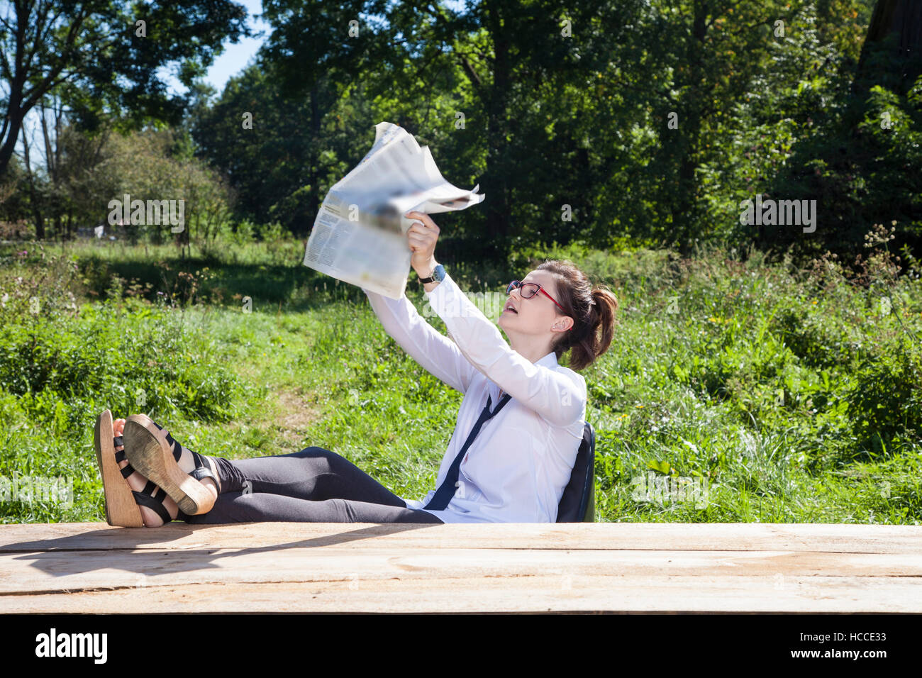 business woman reading a newspaper in disbelief Stock Photo - Alamy