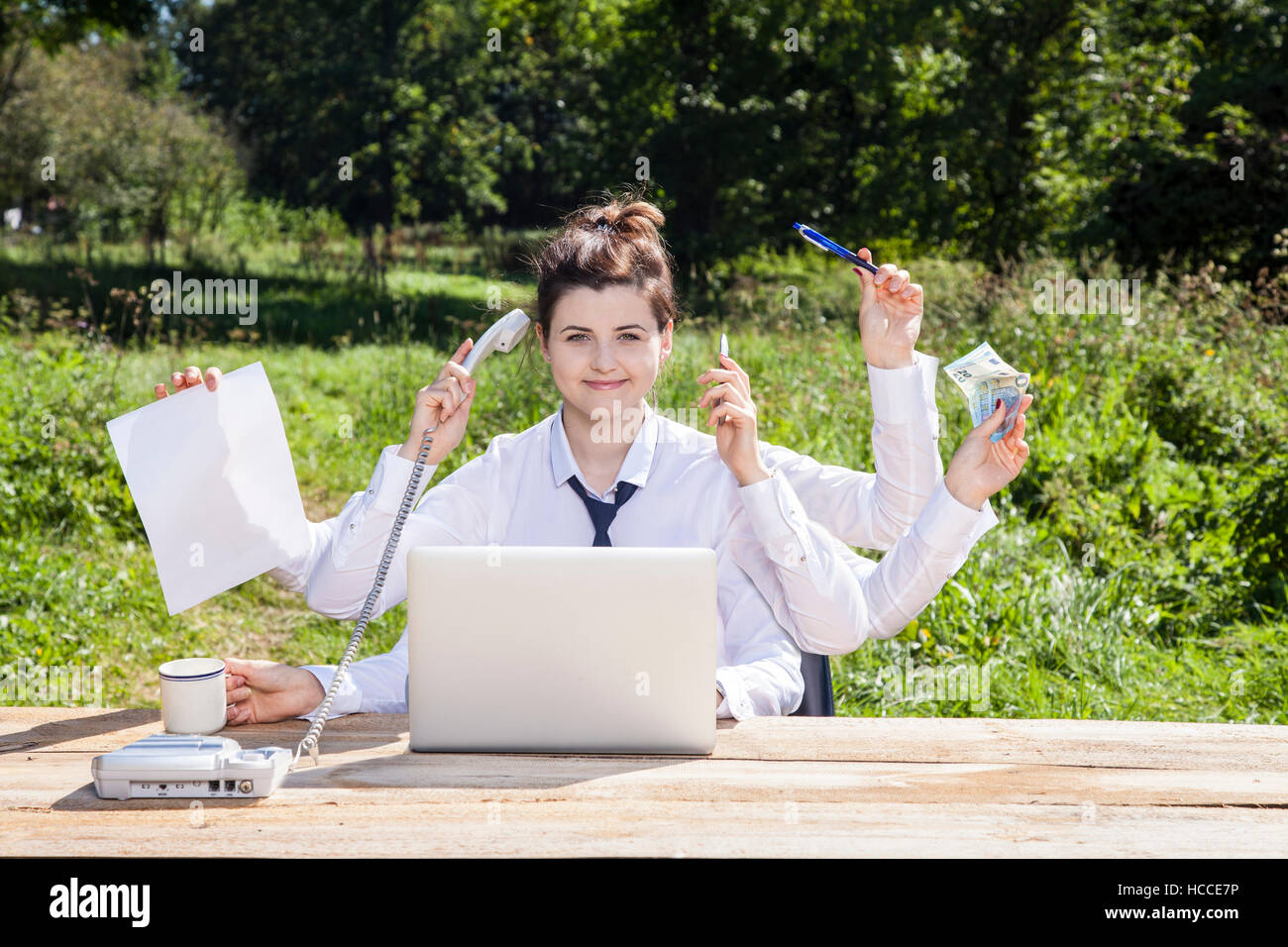 multitasking business woman sitting in the office Stock Photo - Alamy