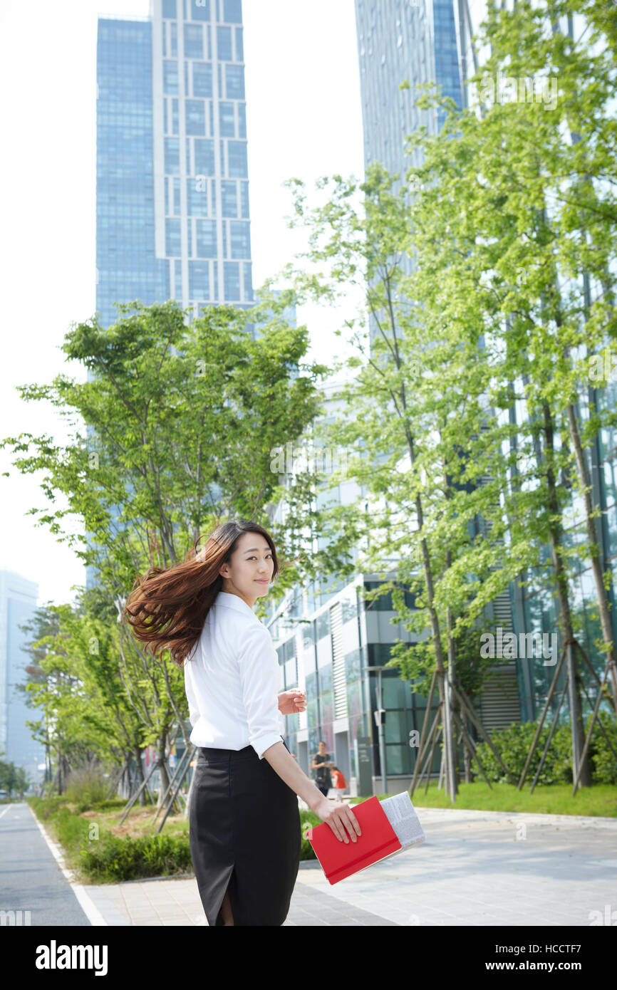 Back of young smiling businesswoman looking back Stock Photo - Alamy
