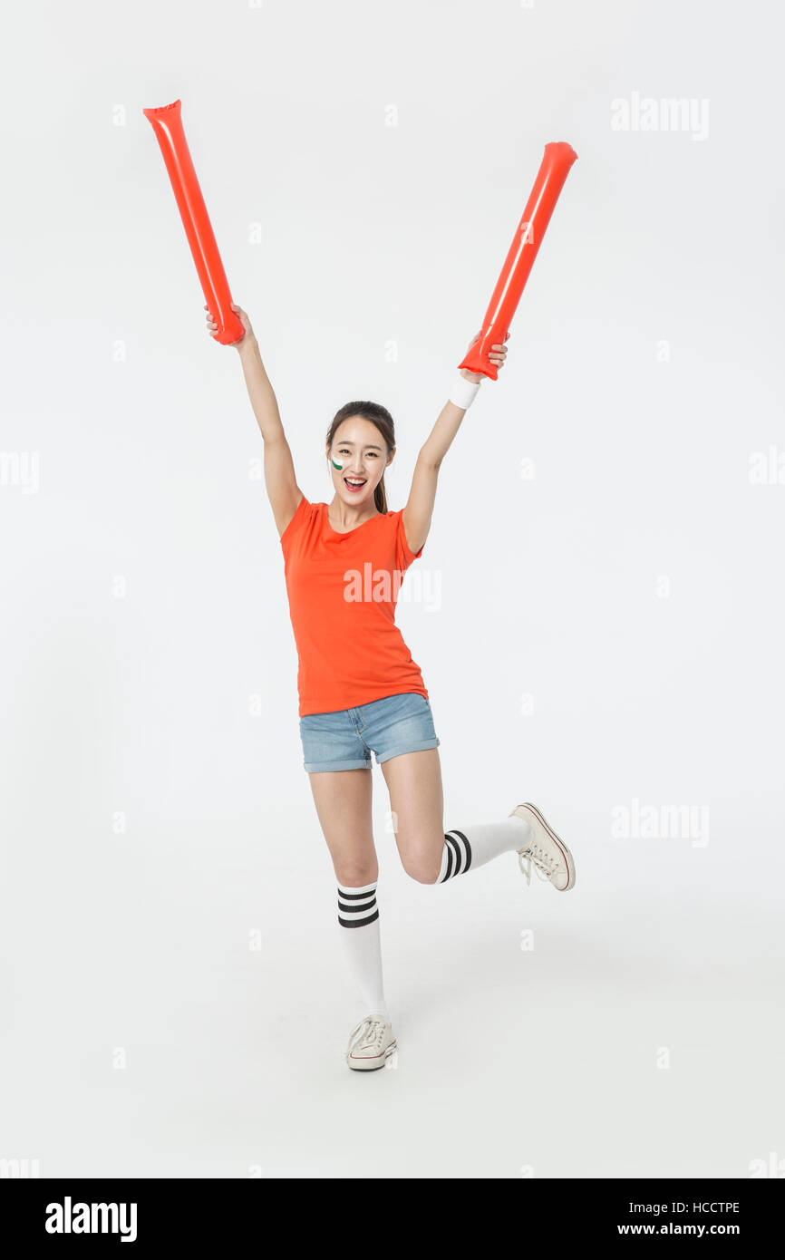Young smiling woman with cheering tools jumping Stock Photo - Alamy