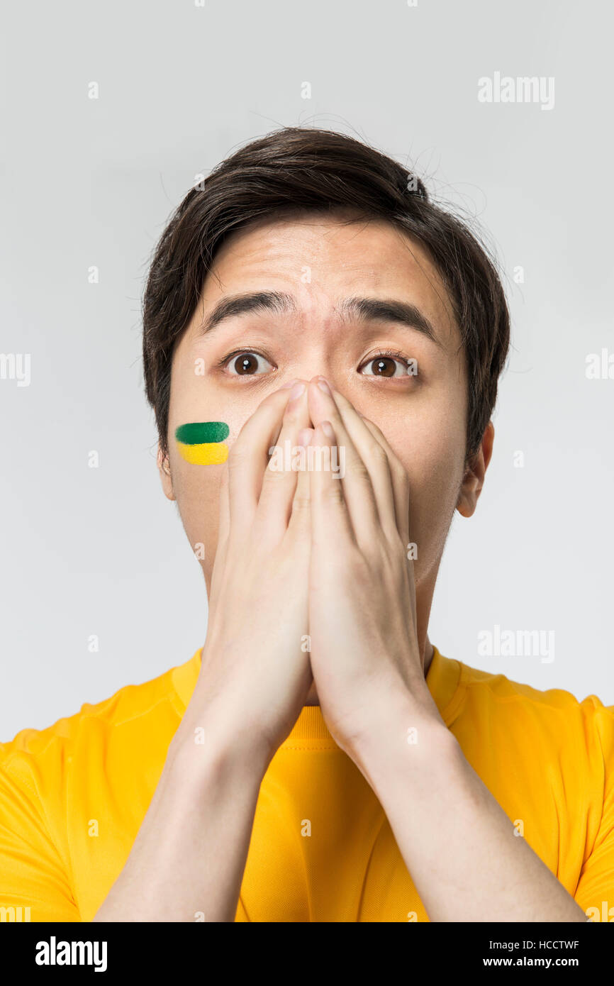 Portrait of young man covering his mouth Stock Photo - Alamy