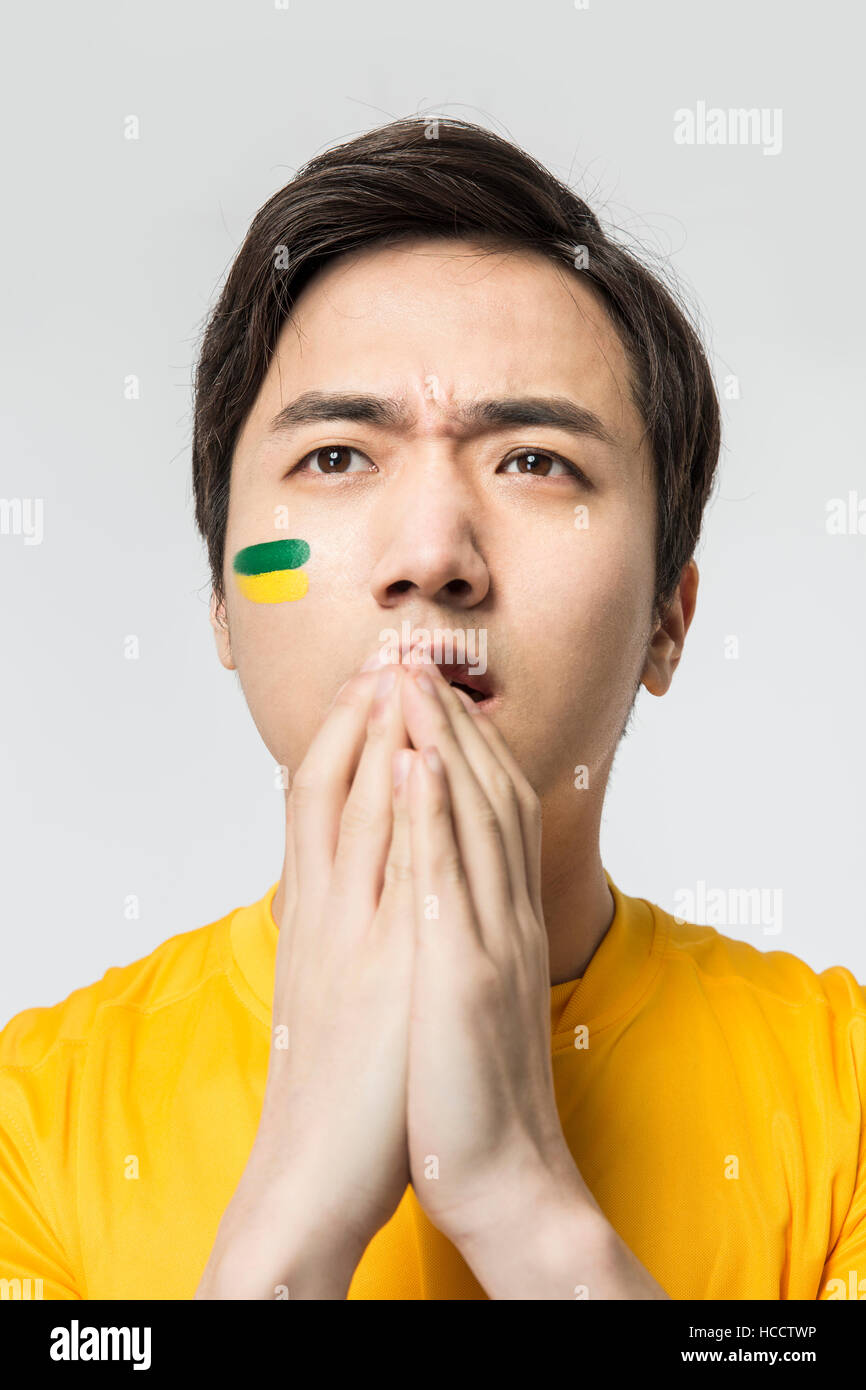 Portrait of young man covering his mouth Stock Photo - Alamy