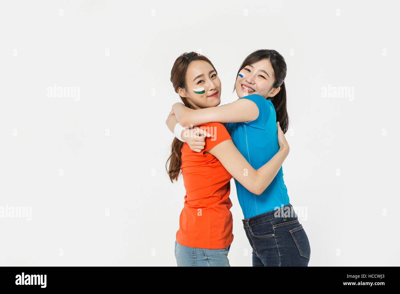 Two young smiling women hugging each other Stock Photo - Alamy