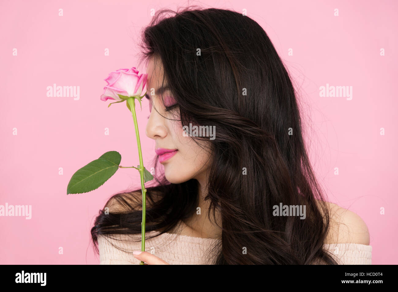 Side view portrait of young woman with pink rose Stock Photo - Alamy