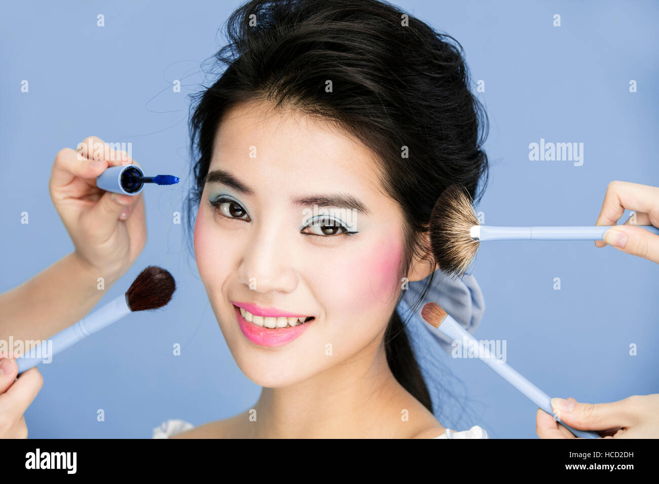 Portrait of young smiling woman putting on makeup Stock Photo - Alamy