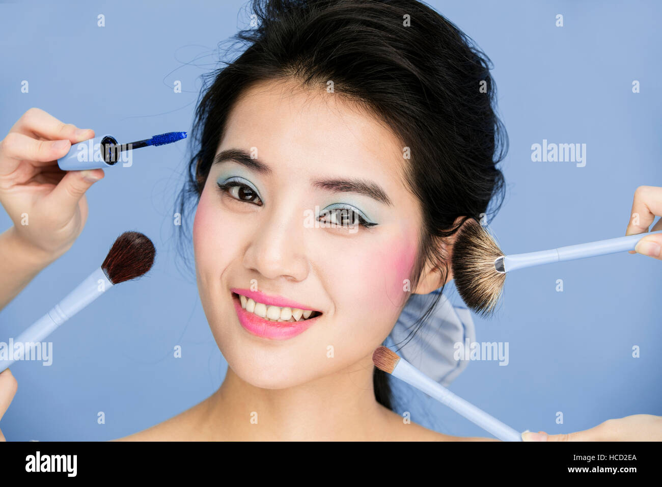 Portrait of young smiling woman putting on makeup Stock Photo - Alamy