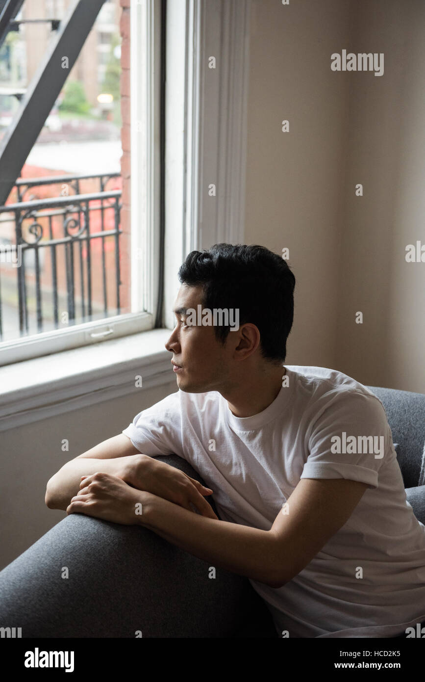 Thoughtful man looking through window Stock Photo - Alamy