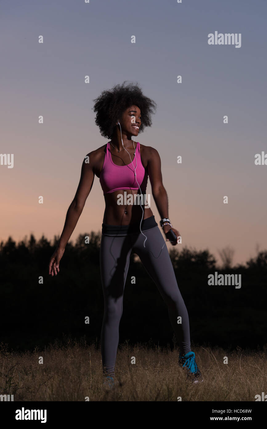 Young healthy black woman is doing stretching exercise relaxing and ...