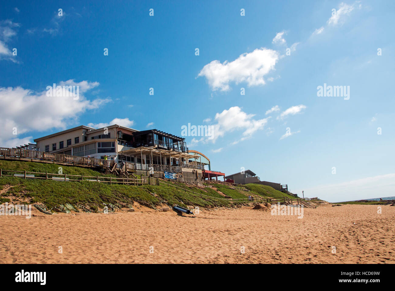 Empty sandy beach against commercial and residential buildings and blue ...