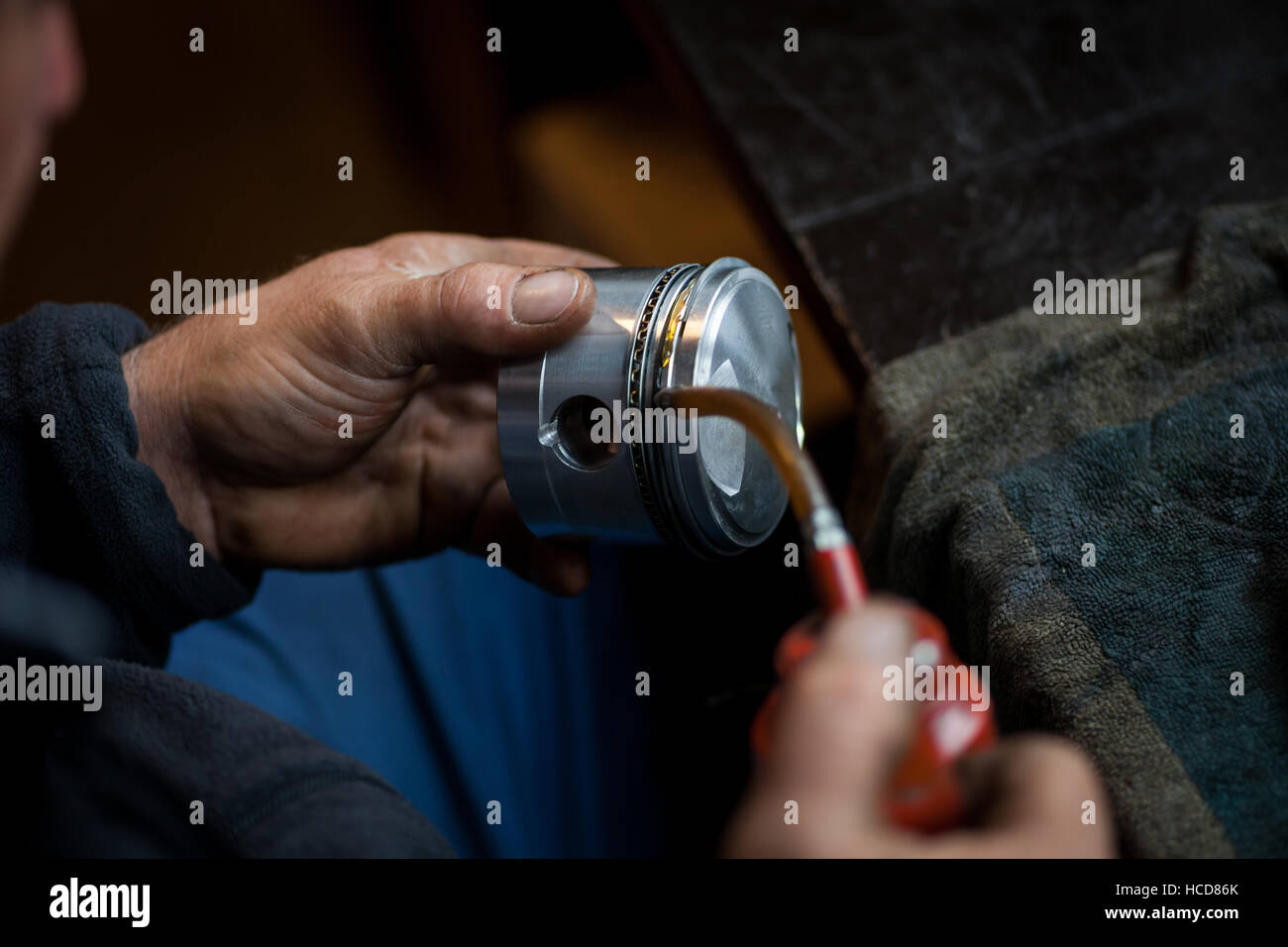 Color image of a mechanic oiling a motorcycle piston Stock Photo - Alamy