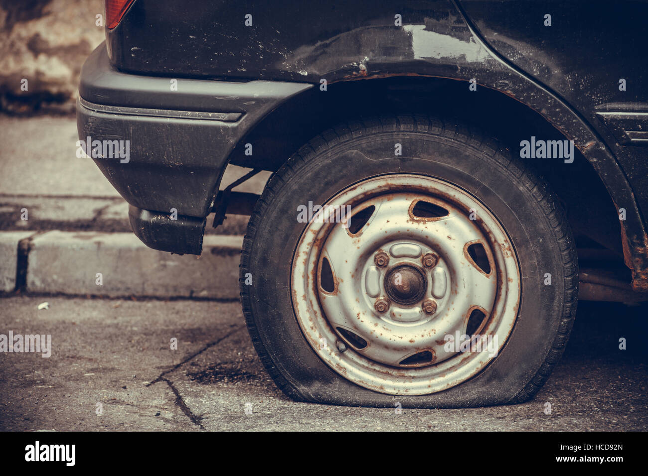 Close up shot of a car with a flat tire Stock Photo - Alamy