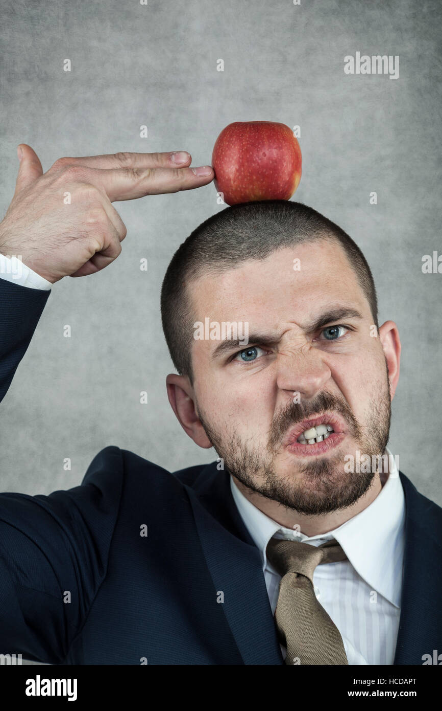 Businessman aiming a gun with his hand in the apple Stock Photo - Alamy