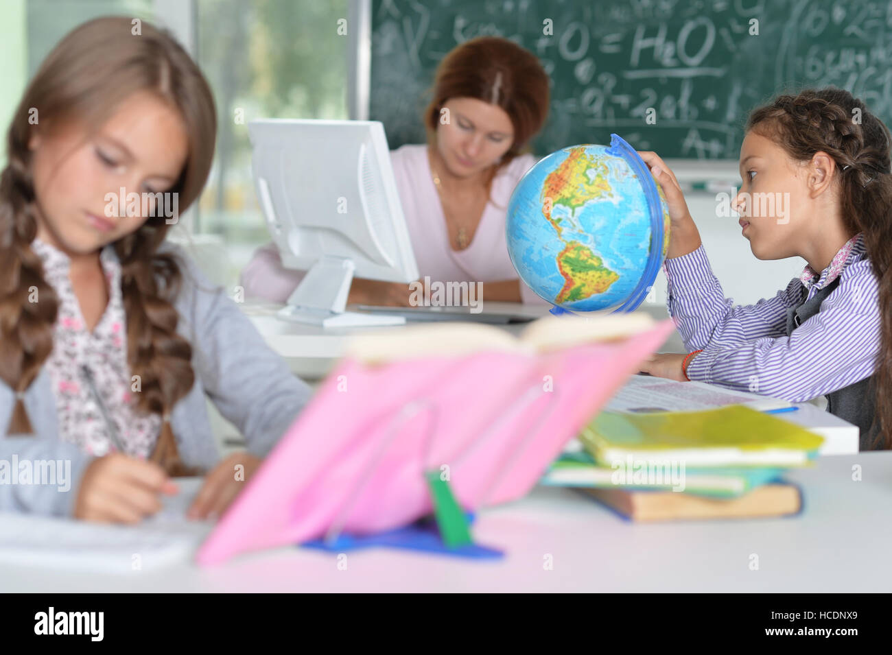 teacher with two girls at lesson Stock Photo - Alamy