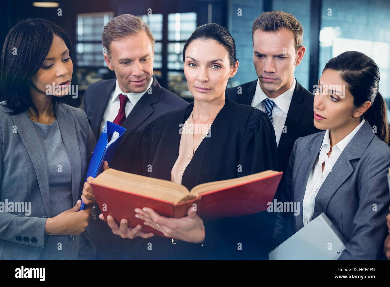 Lawyer reading law book and interacting with business people Stock ...