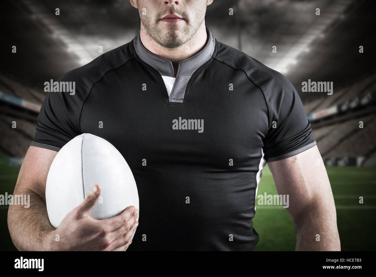 Composite image of tough rugby player holding ball Stock Photo - Alamy
