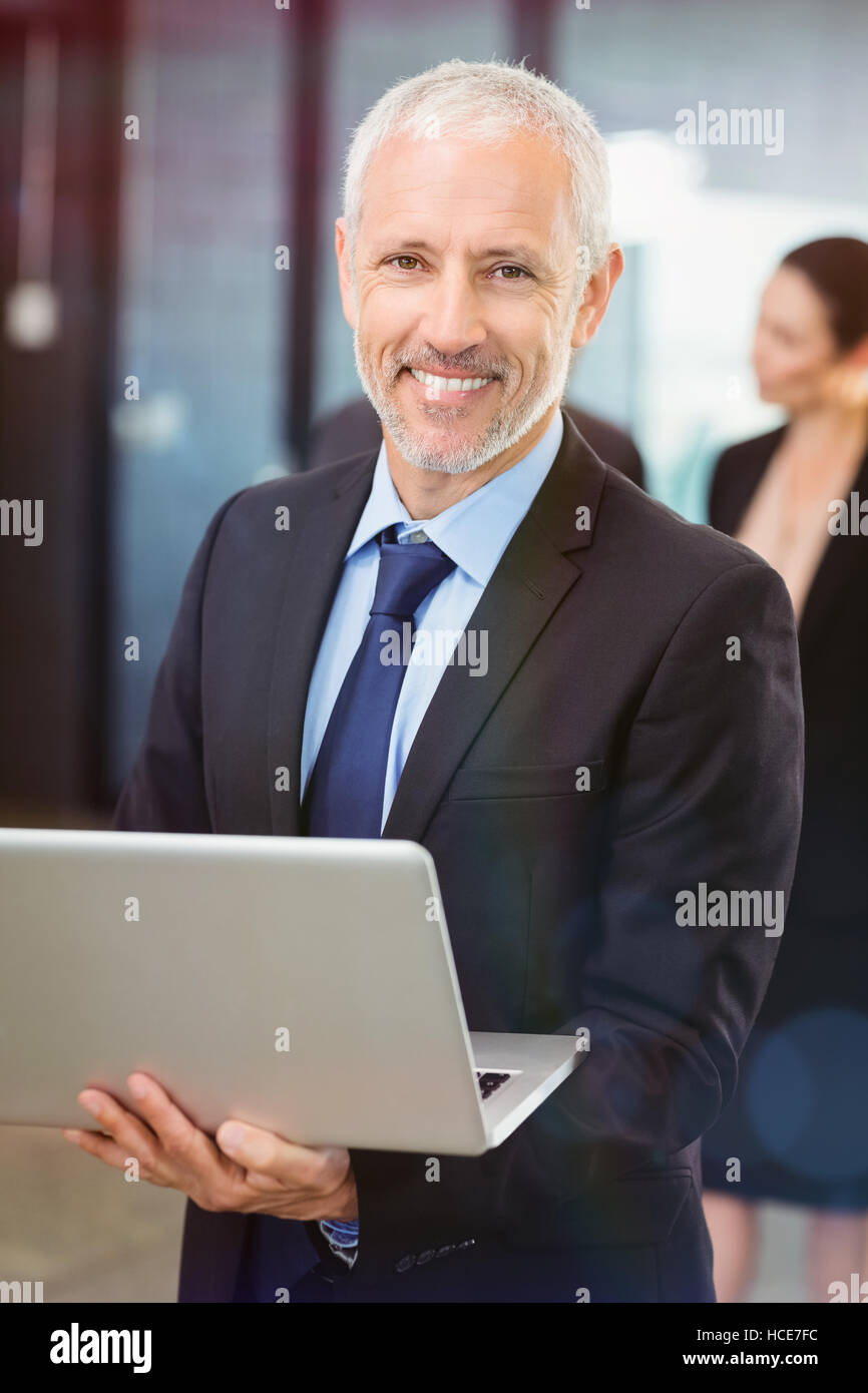 Portrait of cheerful businessman using laptop Stock Photo - Alamy