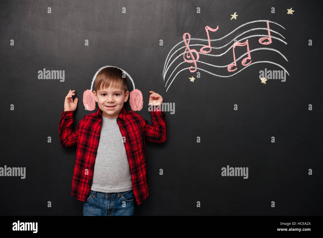 Picture of little kid listening to music over black chalk board with ...