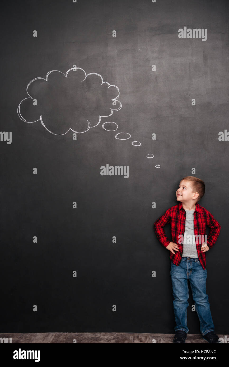 Cute kid thinking with a thought bubble on the chalkboard concept for ...