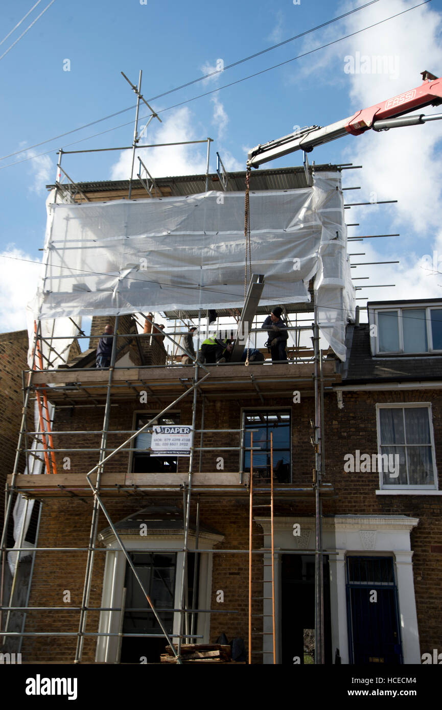 Hackney. Gentrification. Doing up a house - putting on a new roof Stock ...