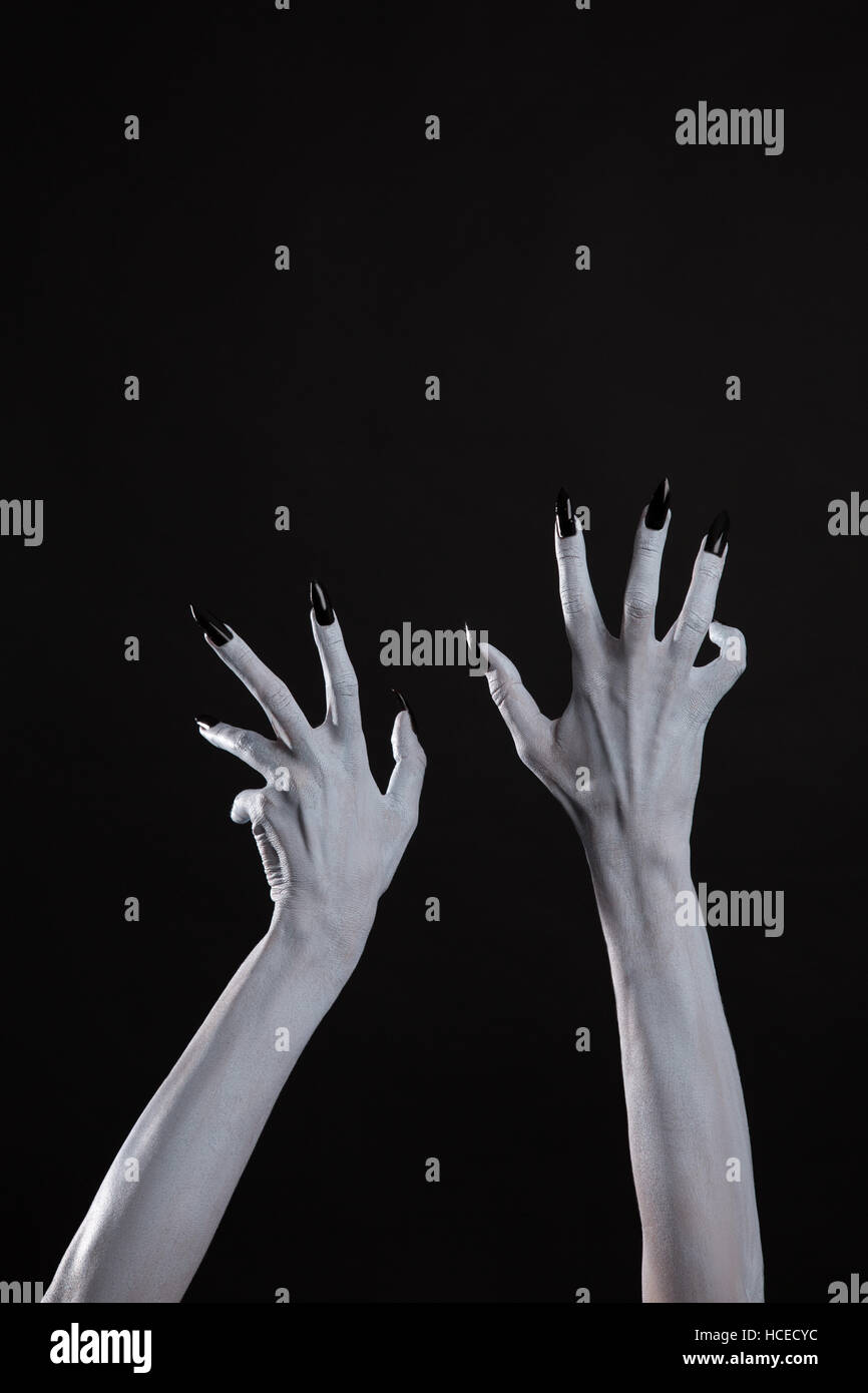 Pale ghost hands with sharp black nails, body art, with copy-space for ...