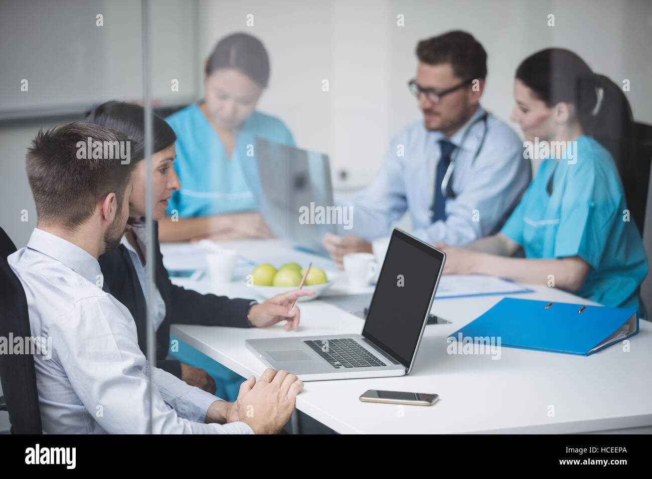 Doctors discussing over laptop in meeting Stock Photo - Alamy