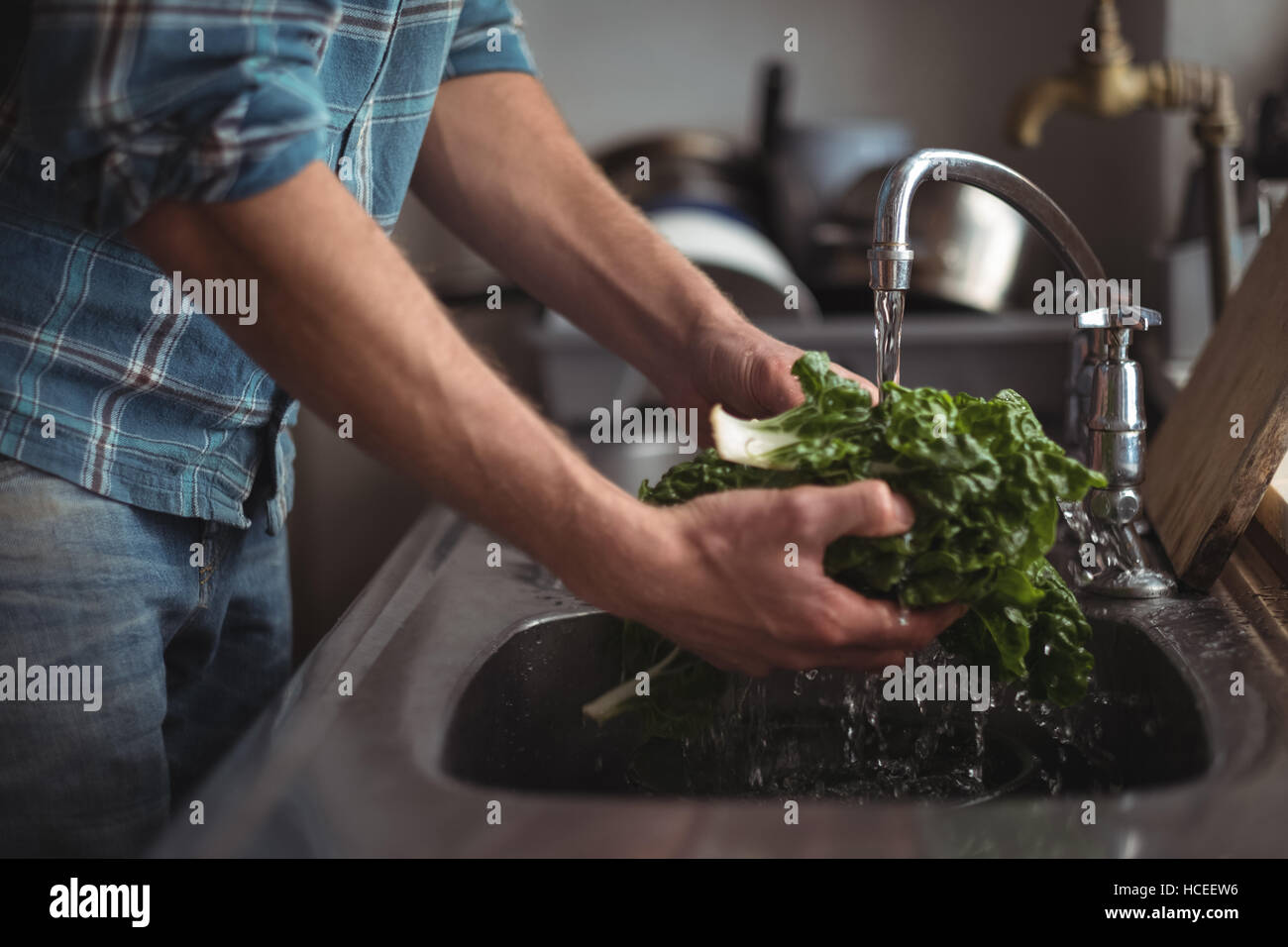 Man washing vegetable in kitchen Stock Photo - Alamy
