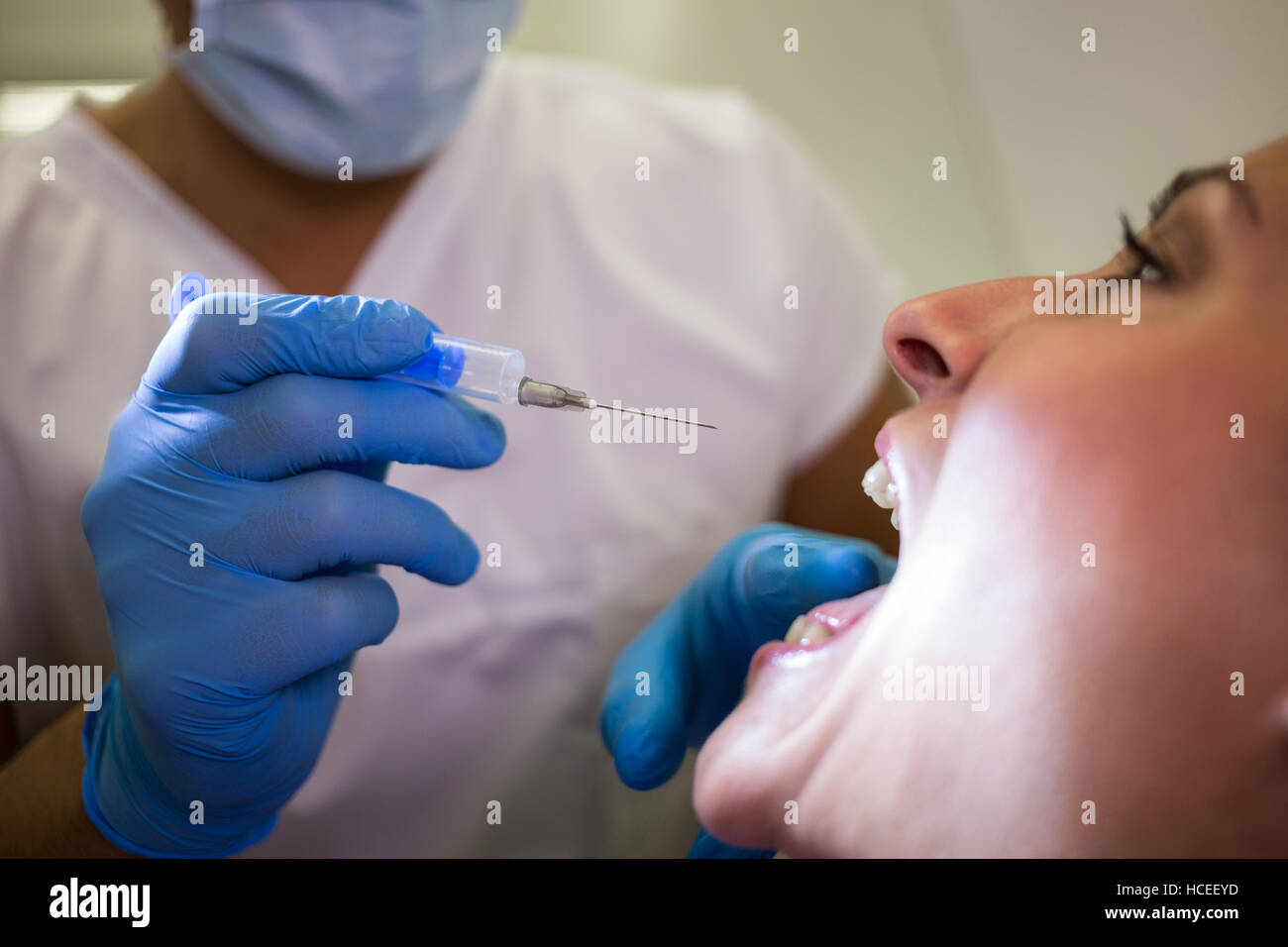 Dentist giving injection to the female patient Stock Photo - Alamy