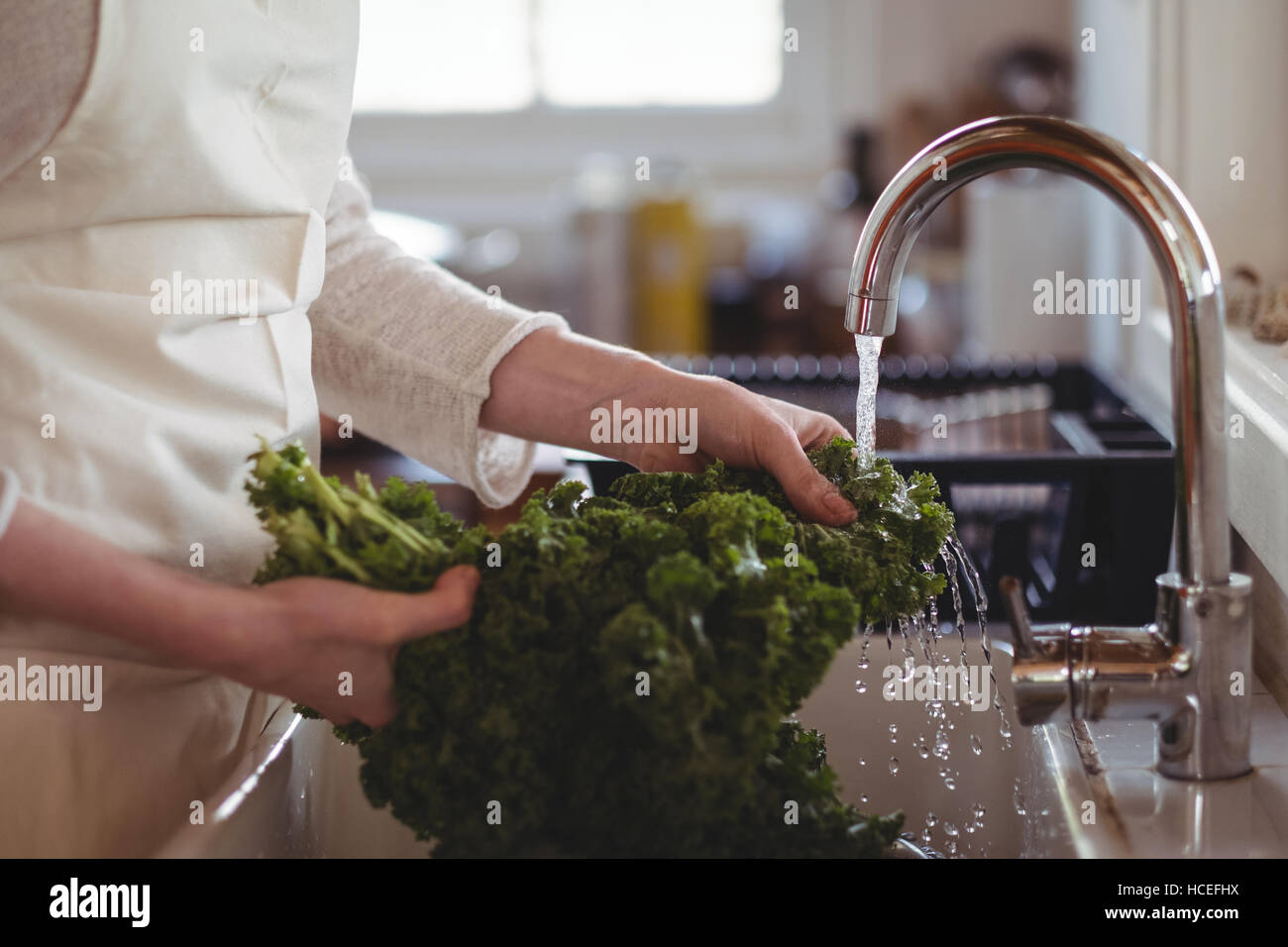 Woman cleaning broccoli in water hi-res stock photography and images ...