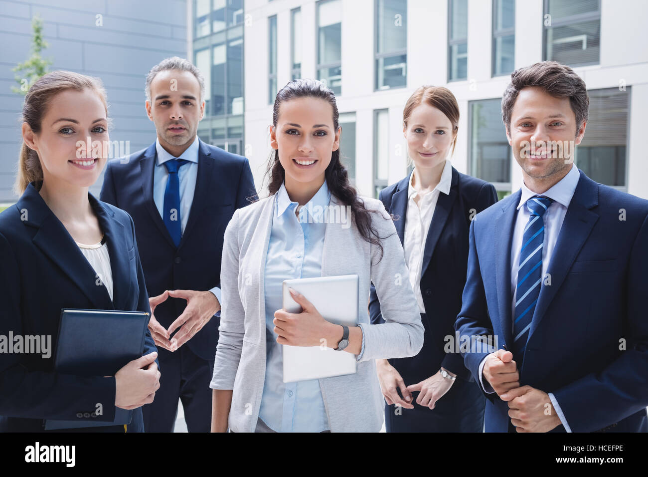 Confident businesspeople standing outside office building Stock Photo ...