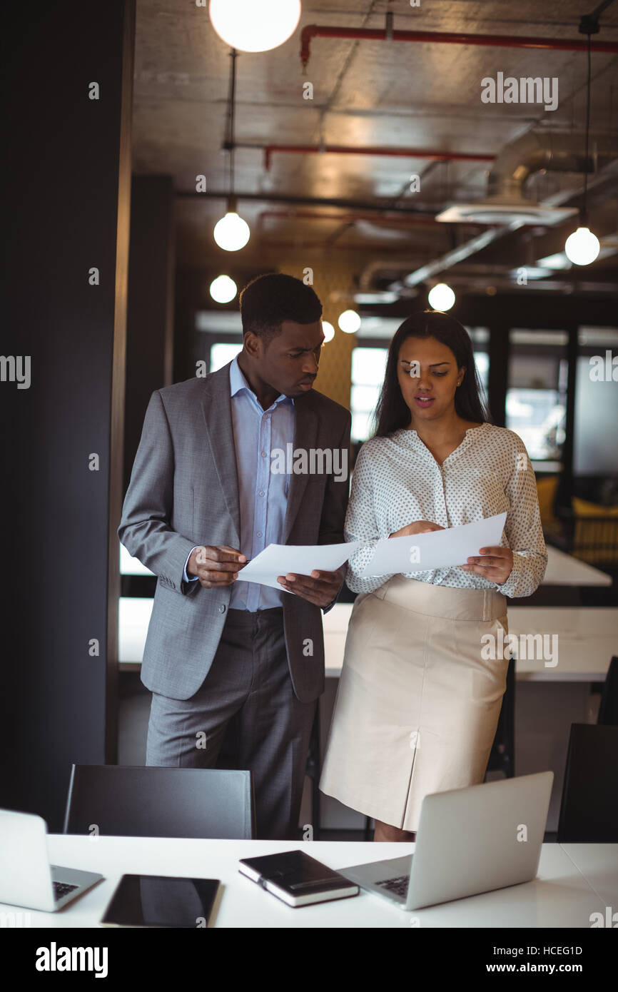 Businessman and a colleague discussing over document Stock Photo - Alamy