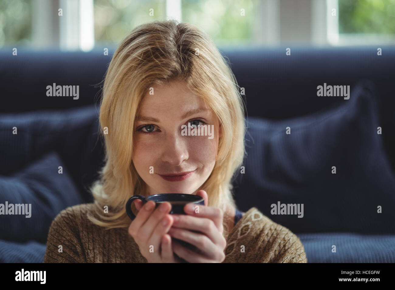 Portrait of beautiful woman having tea in living room Stock Photo - Alamy
