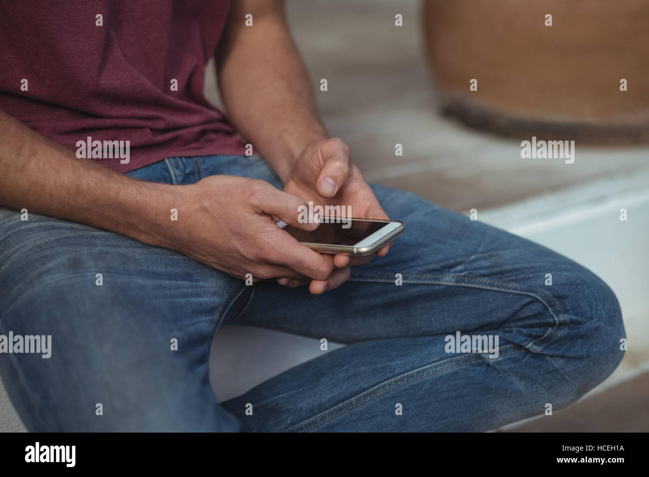 Man sitting and using mobile phone Stock Photo - Alamy