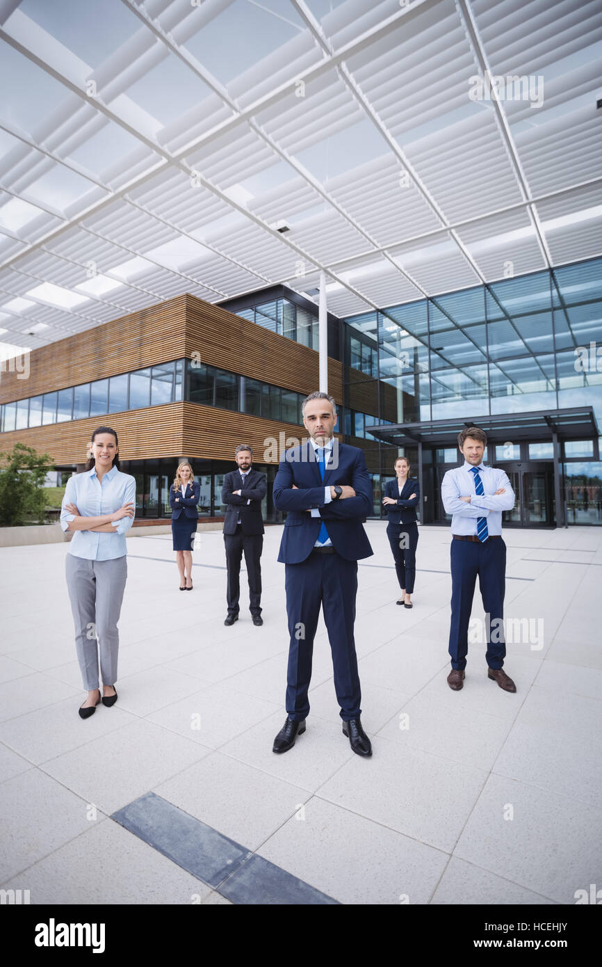 Group of confident businesspeople standing outside office building ...