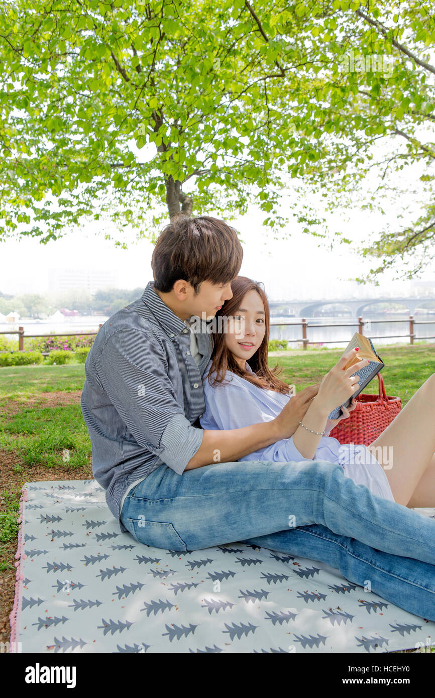 Side view o young couple having picnic in spring Stock Photo - Alamy