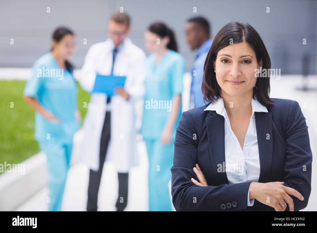 Female doctor standing with arms crossed Stock Photo - Alamy