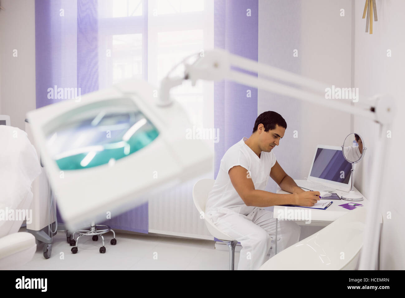 Male doctor sitting on chair hi-res stock photography and images - Alamy