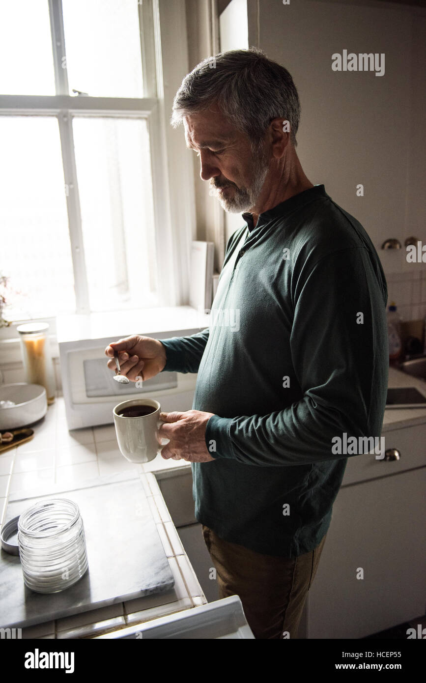 Man preparing a black coffee in kitchen Stock Photo - Alamy
