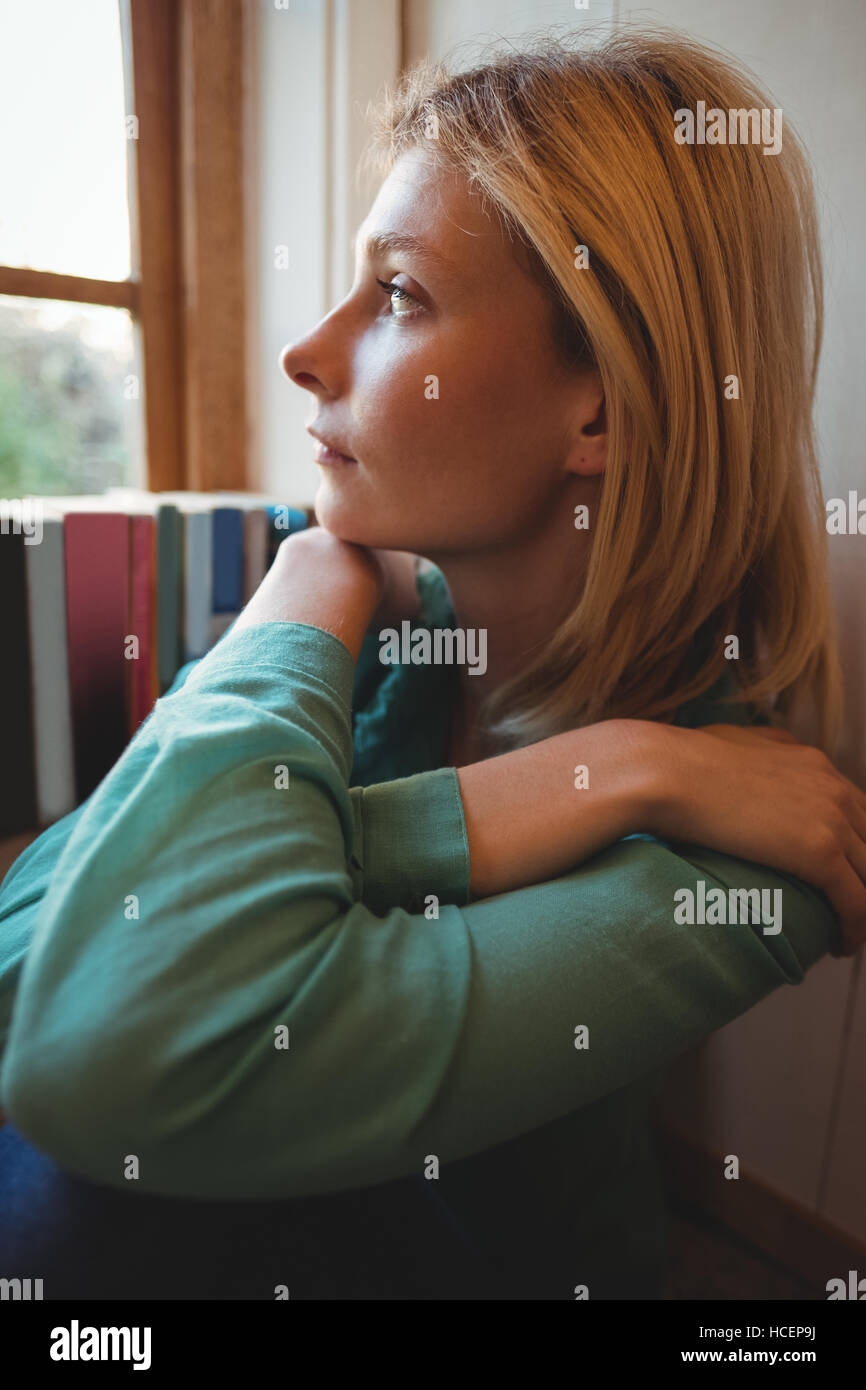 Beautiful woman looking through window Stock Photo - Alamy