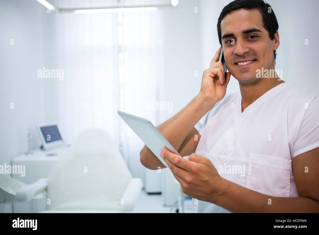 Dentist talking on mobile phone and holding digital tablet Stock Photo ...