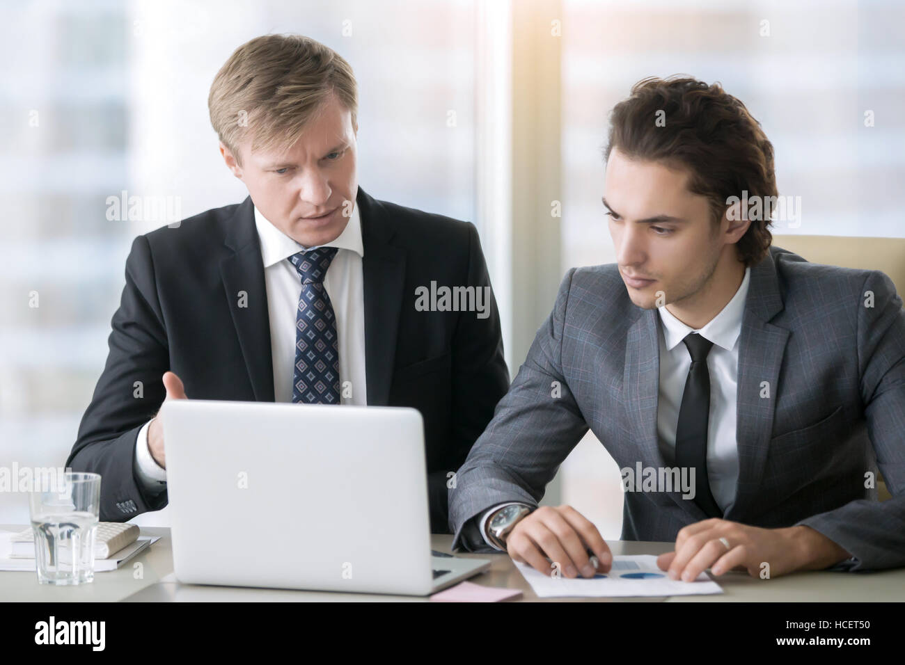 Businessman explaining presentation on laptop screen Stock Photo - Alamy