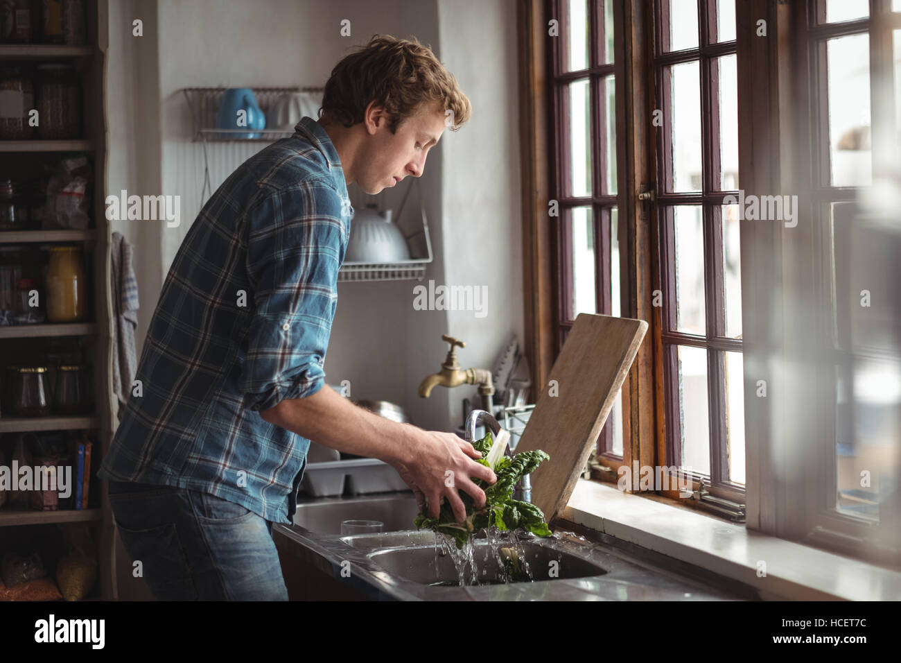 Man washing vegetable in kitchen Stock Photo - Alamy