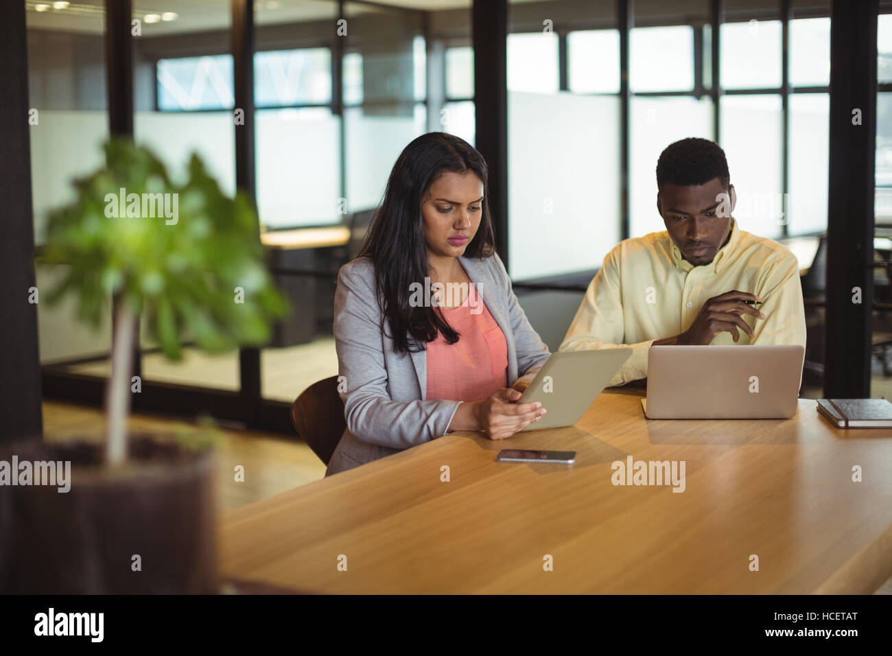 Businessman and a colleague working over digital tablet and laptop ...