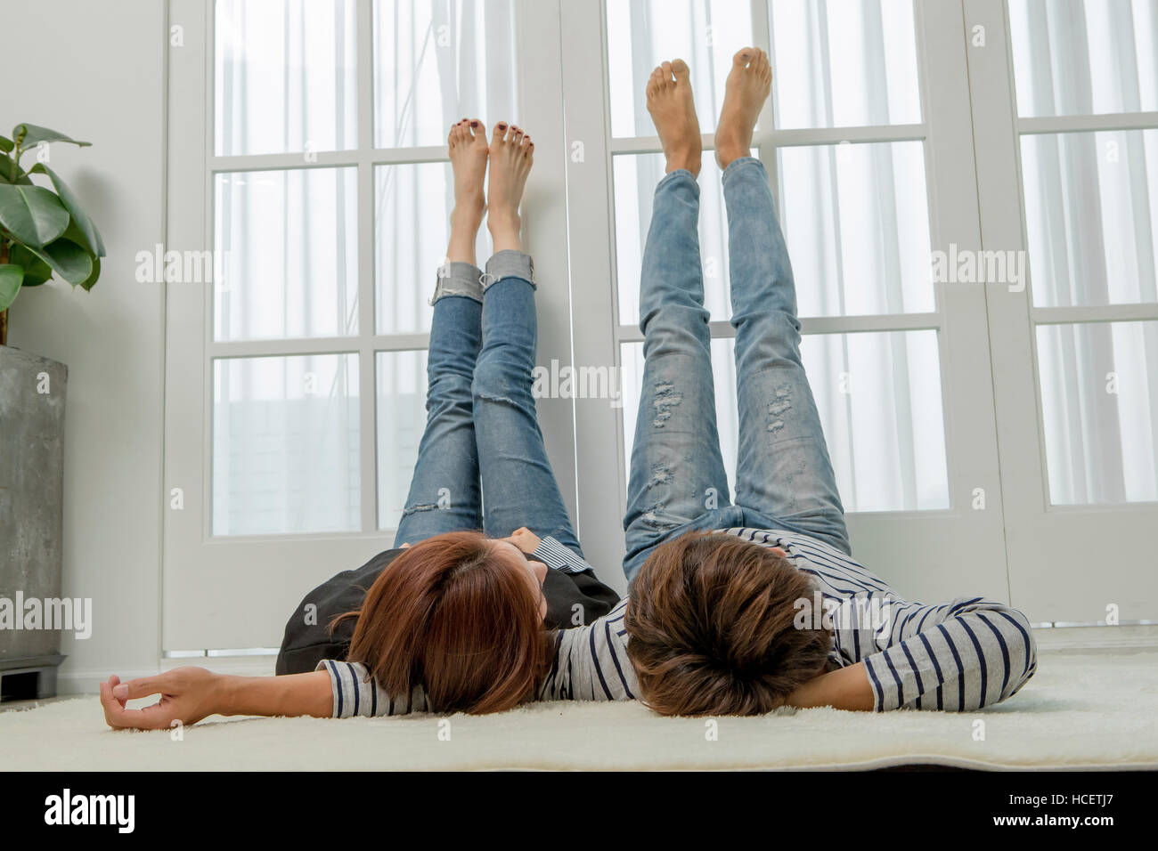 Young couple lying down raising their legs Stock Photo - Alamy