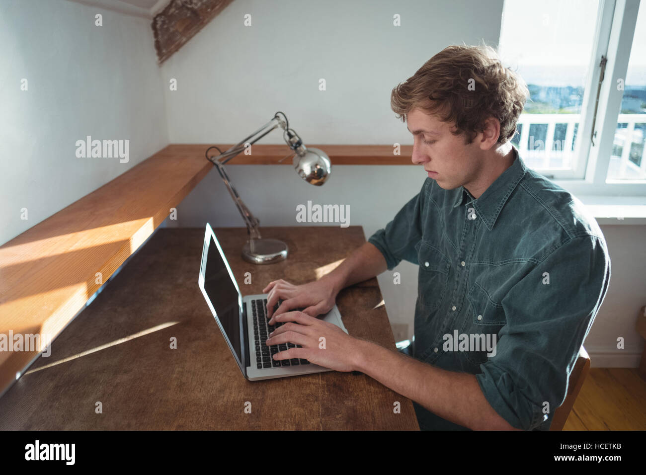 Young man sitting desk working hi-res stock photography and images - Alamy