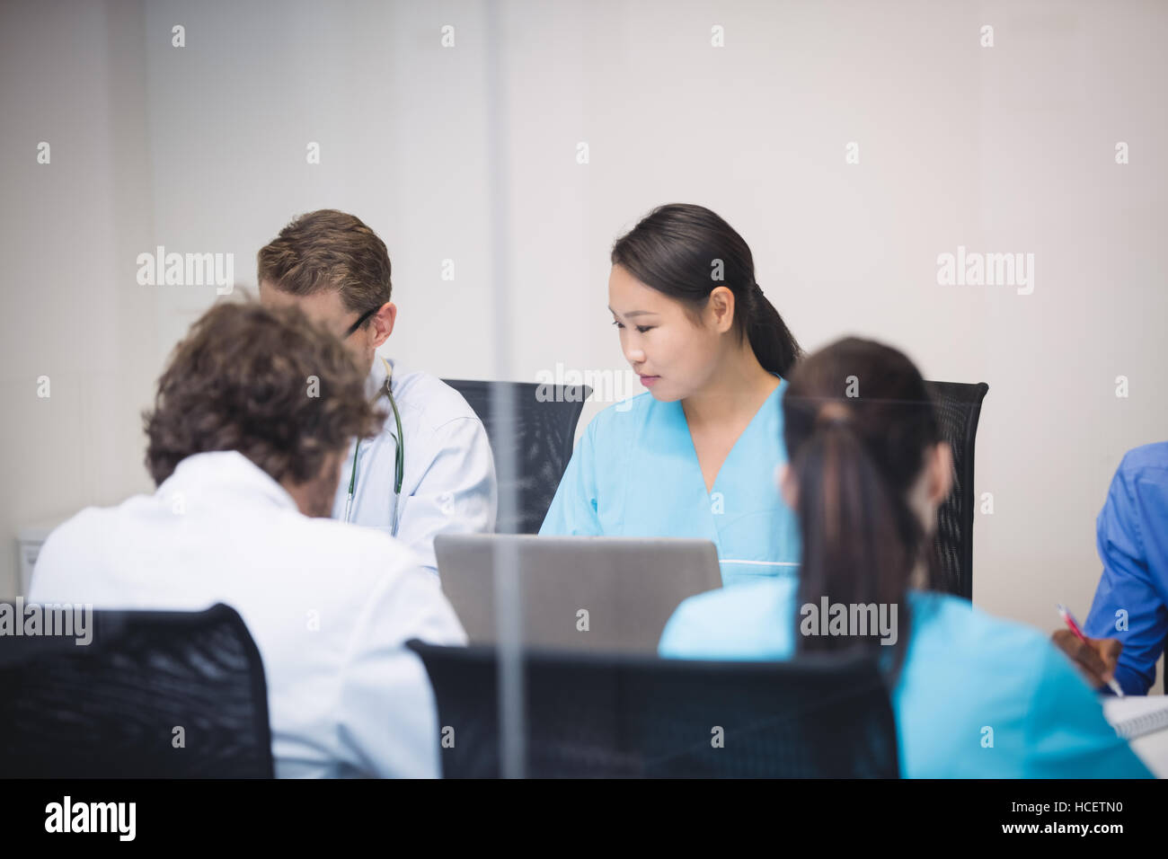 Doctor interacting with colleagues in meeting Stock Photo - Alamy