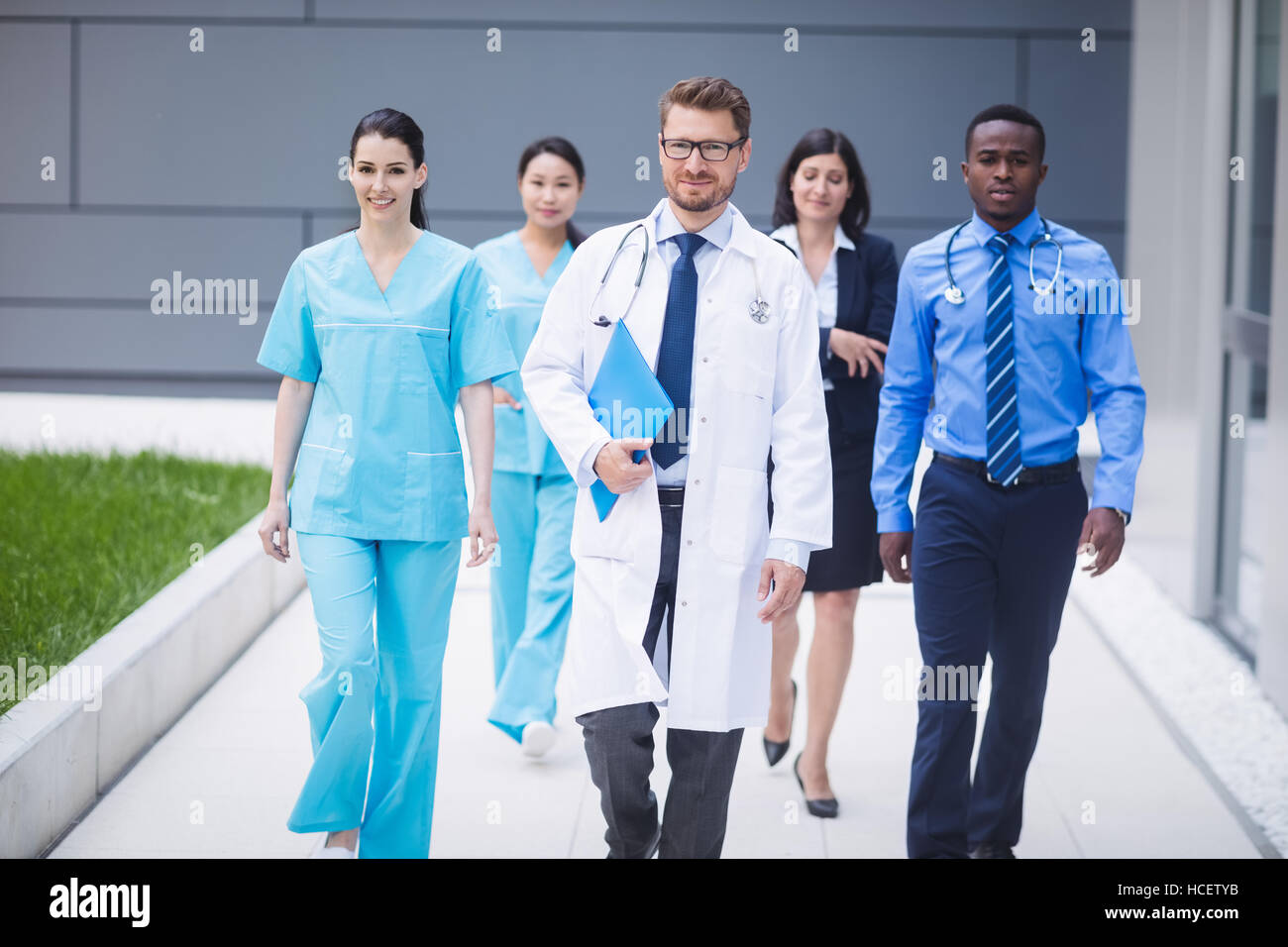 Team of doctors walking in a row Stock Photo - Alamy