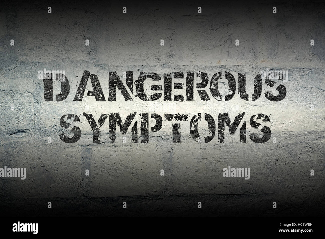 dangerous symptoms stencil print on the grunge white brick wall Stock ...